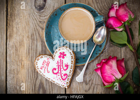 Gingerbread cookies with cup of coffee and roses on blue Stock Photo ...