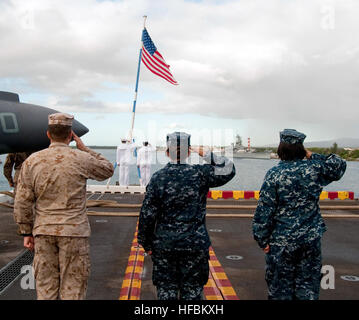 Sailors and Marines render a hand salute as the multi-purpose ...