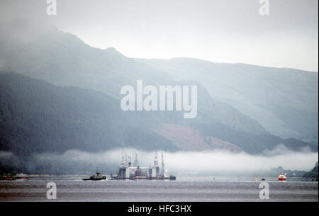 A tug approaches the large auxiliary floating dry dock USS Los Alamos ...