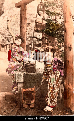 Circa 1900, sepia Japanese postcard. Woman, geisha kneeling on floor ...