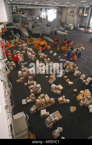 US Navy Crew Members sort a large shipment of mail in the hangar bay ...