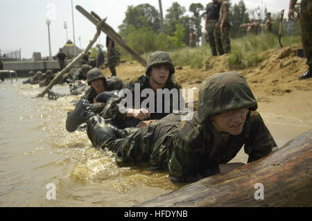 US Navy Midshipmen crawl along a beach through obstacles as part of Sea ...