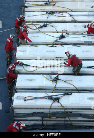 Flight deck crew members and ordnance crew members use an HLU-196 bomb ...