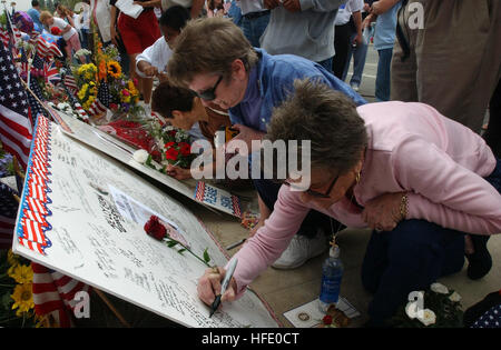 US Navy Mourners write their condolences on a memory board for former ...