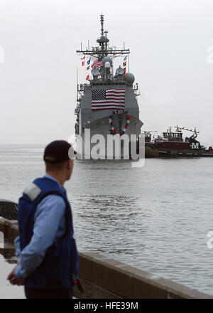 US Navy A line handler waits on the pier for the guided missile cruiser ...
