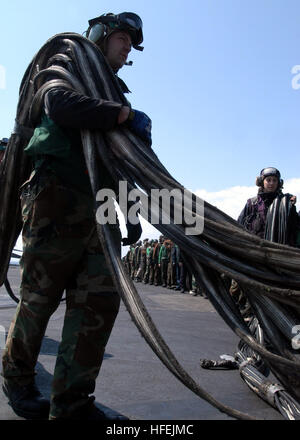 US Navy Crewmembers re-stow an aircraft barricade after a flight deck ...