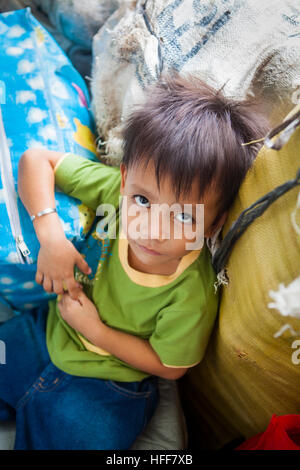 A homeless Filipino child about 2 - 3 years old sleeps on a piece of ...