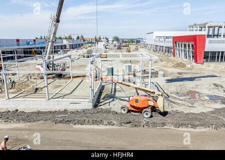 Cherry picker has elevated platform with riggers in safety basket at ...