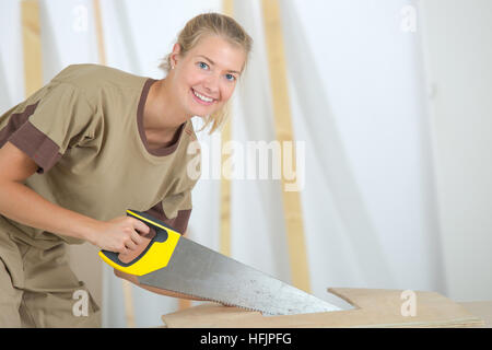 Woman using handsaw Stock Photo - Alamy