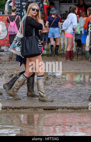 Festival goers walk through the mud during the Leeds Festival at ...