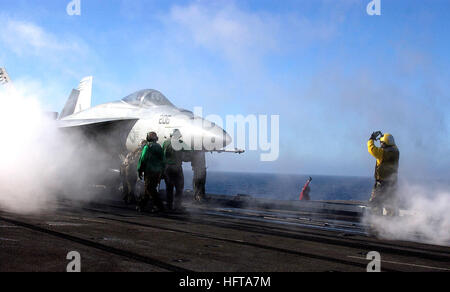 US Navy Aircraft handler prepare to launch an F-A-18C Hornet from the ...