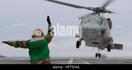 US Navy A landing signal enlistedman (LSE) guides an HH-60H Seahawk ...