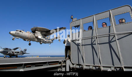 Landing signal officers (LSO) and lookouts watch from behind the LSO ...