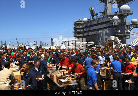 US Navy Sailors swarm food tables on the flight deck of USS Ronald ...