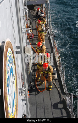 Crew members aboard the frigate USS LANG (FF 1060) set up a manila rig ...