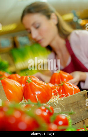 Young female shop assistant sorting ginseng root in grocery shop Stock ...
