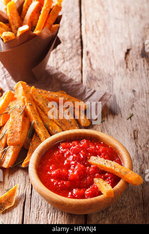 Slices of baked potato with rosemary and ketchup on a white background ...