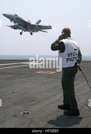 A landing signal officer (LSO) watches as an F-4S Phantom II aircraft ...