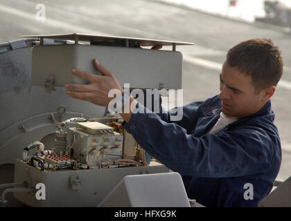 US Navy Electronics Technician Third Class performs maintenance on the ...