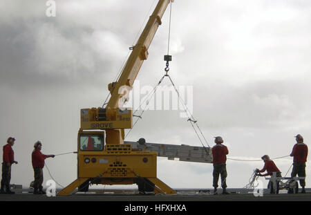 US Navy Fire Controlmen steady a Rolling Airframe Missile (RAM) casing ...