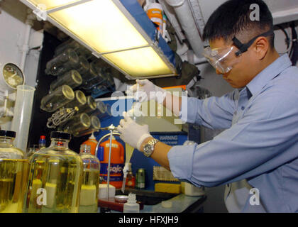 US Navy Airman adds water to a sample of JP-5 fuel while performing a ...