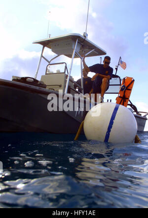 US Navy Dive Supervisor Chief Hull Technician foreground, monitors the ...