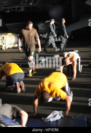 US Navy Sailors workout in the hangar bay aboard the Nimitz-class ...