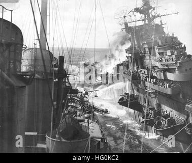 USS Santa Fe (CL-60) fighting fires aboard the burning USS Franklin (CV ...