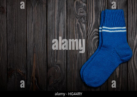 Knit blue wool socks on dark wooden background Stock Photo - Alamy