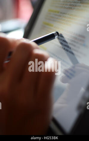 Female student using marker pen to highlight text in a book. Woman ...