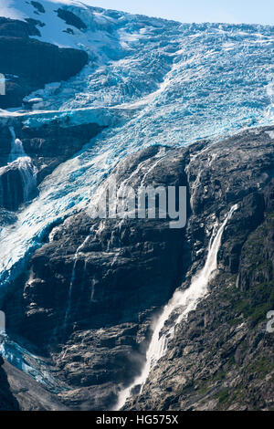 ice waterfall in a glacier in Norway with Rocky Mountains an lake from ...