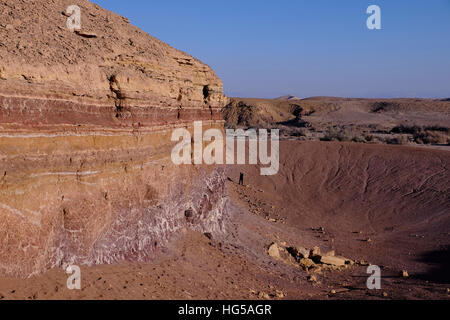 A magmatic dike cross-cutting horizontal layers of color bands in a ...
