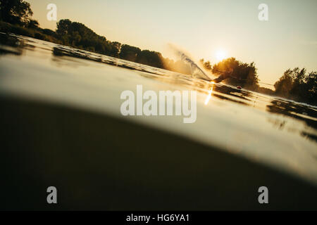 Low angle shot of man wakeboarding on a lake. Man water skiing at ...