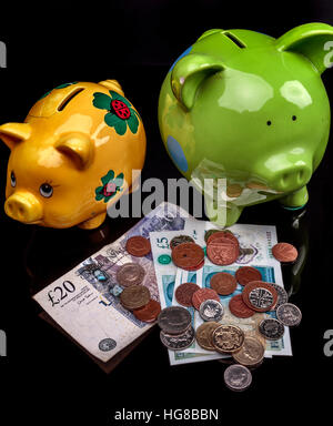 Black ceramic piggy bank with UK coins on reflective black background ...
