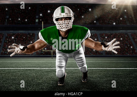 Football Player with a green uniform making a catch on a green ...