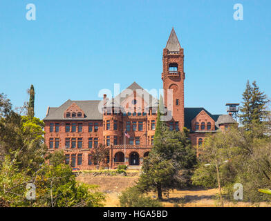 Three story abandoned brick building from exterior parking lot with ...