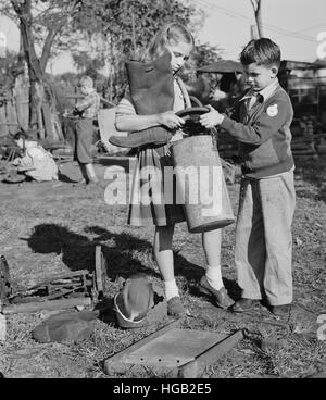 Young children collecting scrap for donation to their war industries ...