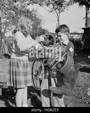 Young children collecting scrap for donation to their war industries ...