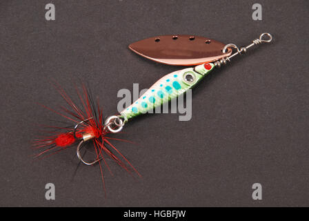 Fishing lure in the shape of fish on a red background Stock Photo - Alamy