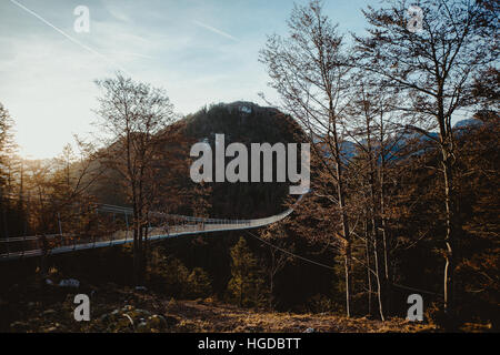 A Suspension bridge between two mountains at sunset Stock Photo - Alamy