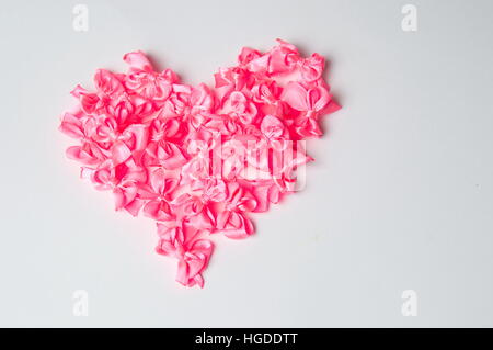 Heart made of pink satin ribbon on table against blurred lights Stock ...