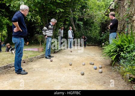 Locals play the French game of Boules or Petanques by the beach and ...
