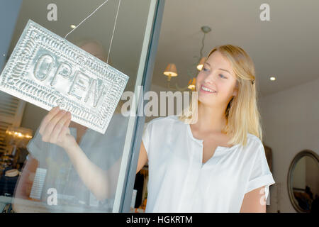 Lady turning shop sign to open Stock Photo - Alamy