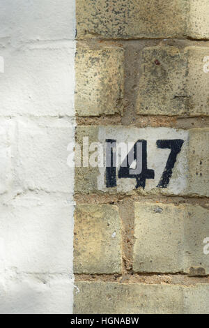 House number 147 painted sign on wall Stock Photo - Alamy