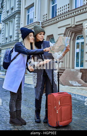 Two friends tourists choose attractions on the map Stock Photo - Alamy