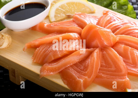 Fresh sliced salmon sashimi arranged neatly in clear plastic takeaway ...