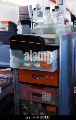 Cabin crew / air stewardess serves drinks and snacks to passengers from ...