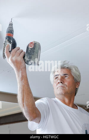 construction builder drilling ceiling Stock Photo - Alamy