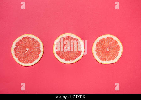 Cross sections of grapefruit against orange background Stock Photo - Alamy