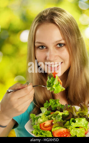 Pretty young woman eating salad on sofa at home. Healthy lifestyle ...